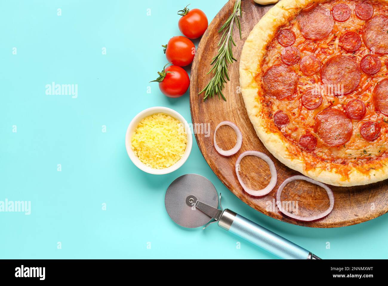 Board with delicious pepperoni pizza and ingredients on turquoise ...