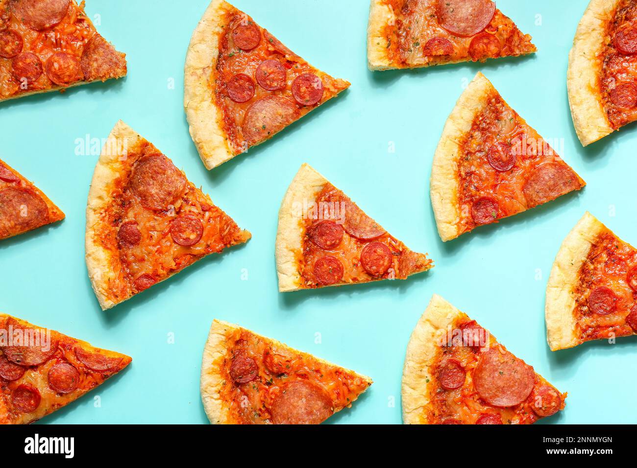 Many slices of delicious pepperoni pizza on turquoise background Stock ...