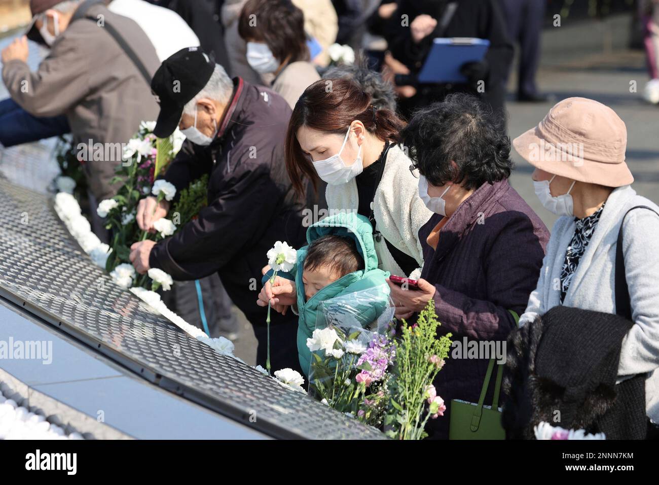 People pray for the victims of the Great East Japan Earthquake and Tsunami in front of a ...
