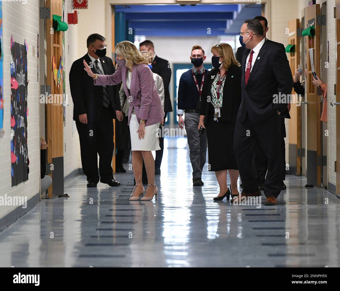First lady Jill Biden waves to students in a classroom as she tours Benjamin Franklin Elementary ...