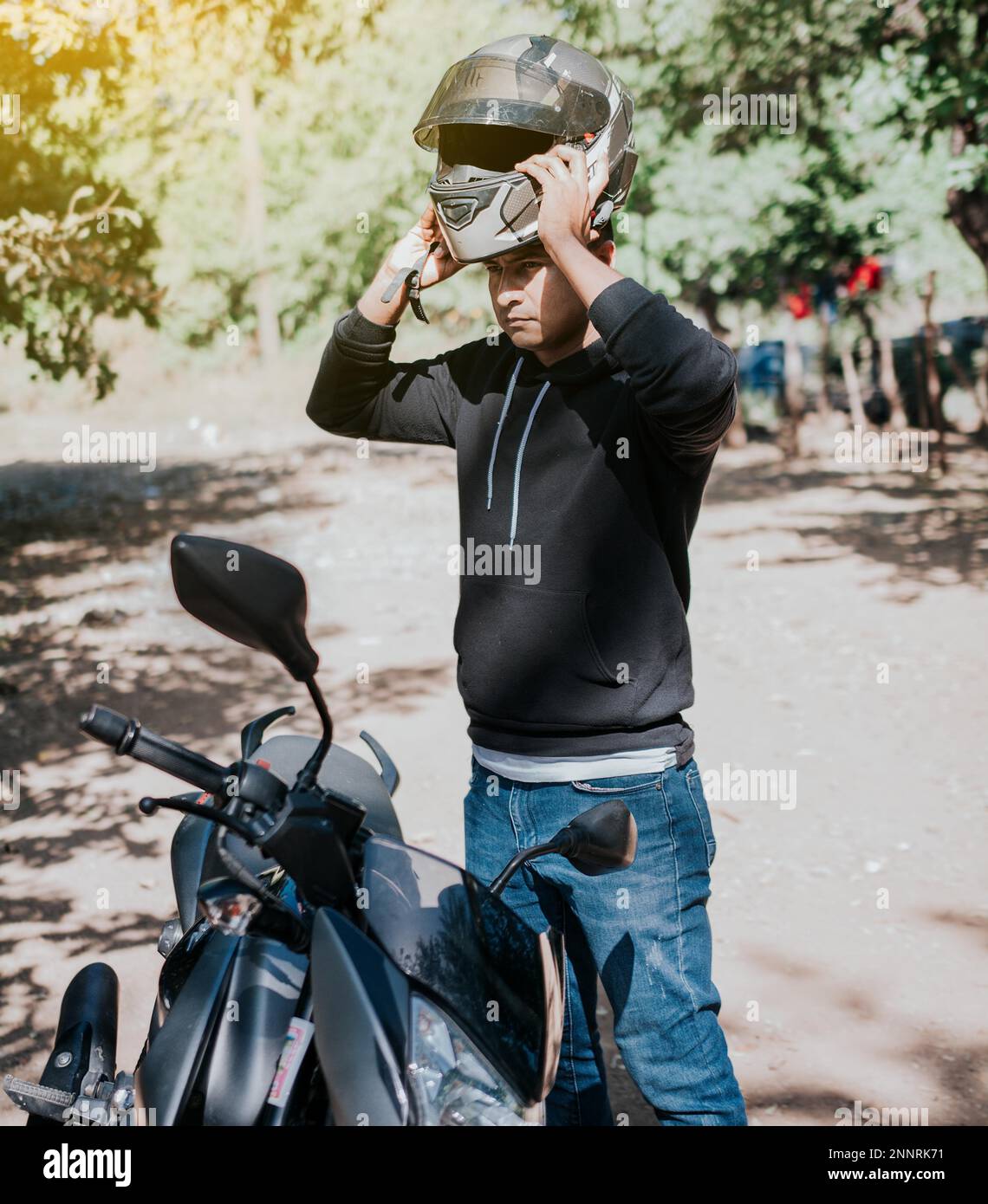 Motorcyclist putting on helmet hi-res stock photography and images - Alamy