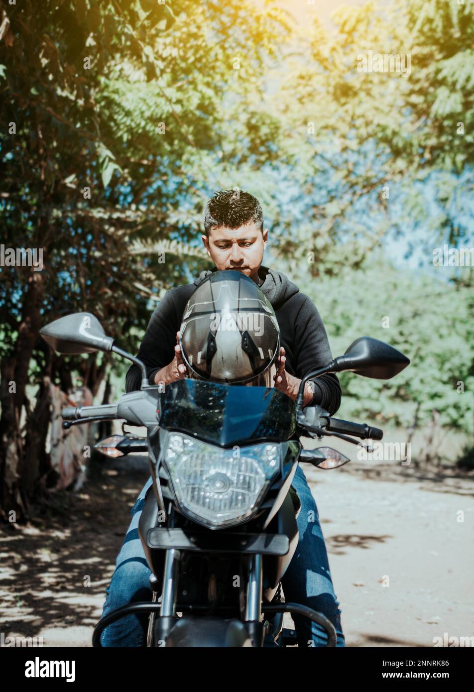 Motorcyclist putting on safety helmet, Biker motorcycle safety concept ...