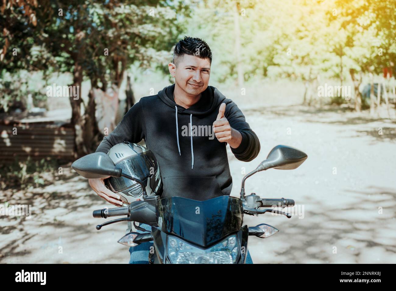 Biker on his motorbike holding safety helmet with thumb up. Concept of ...