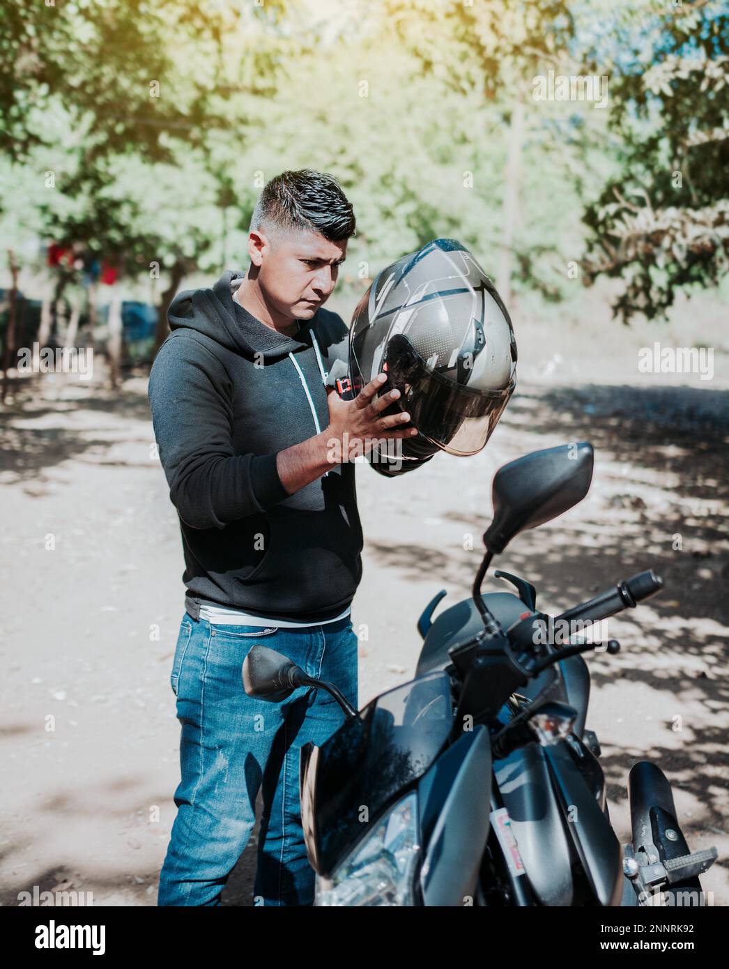 Man on motorcycle putting on helmet. Person on motorcycle putting on ...