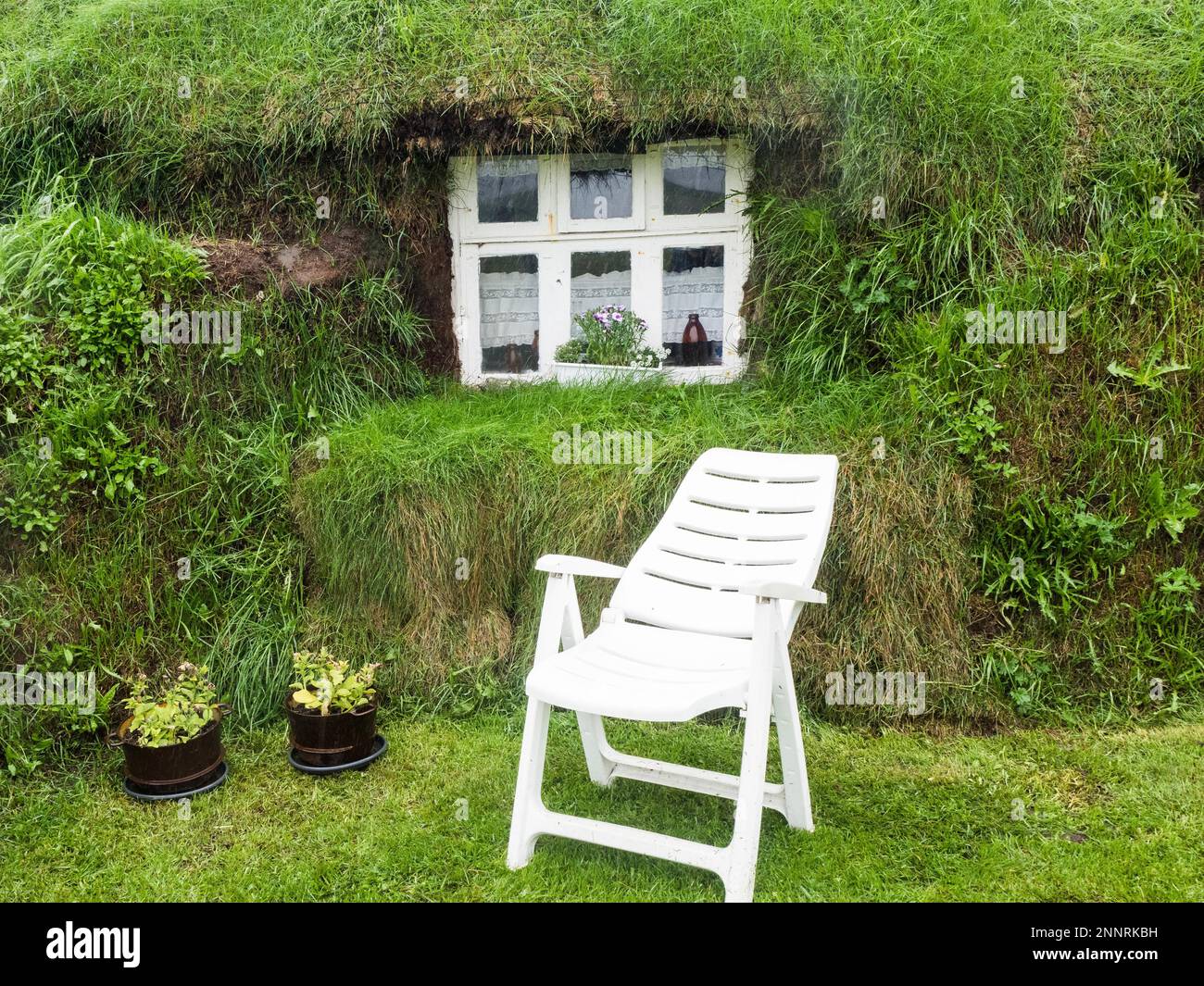 Folding chair in front of window, traditional wooden house protected ...