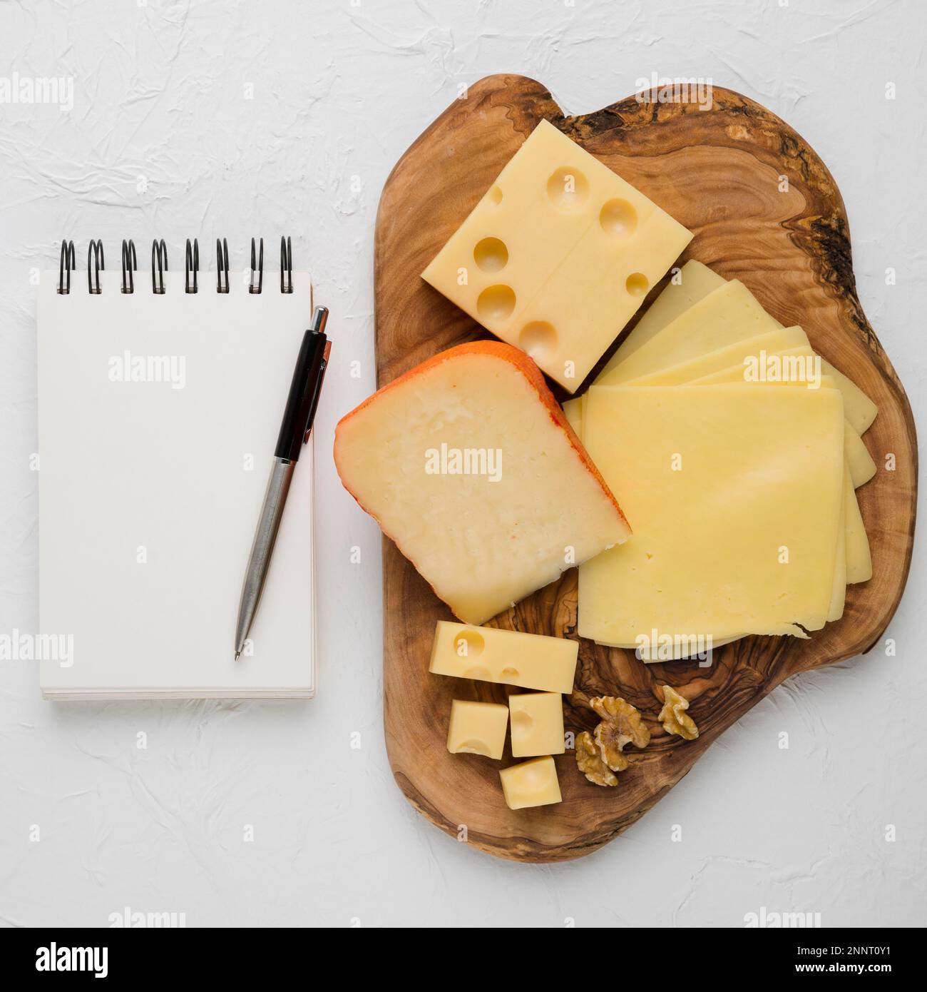 delicious cheese platter blank spiral dairy with pen against plain ...