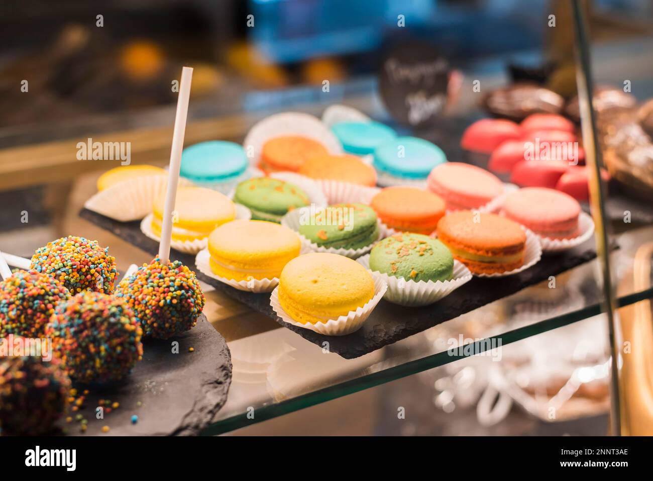 Chocolate cake pops with colorful sprinkles macaroons display cabinet ...