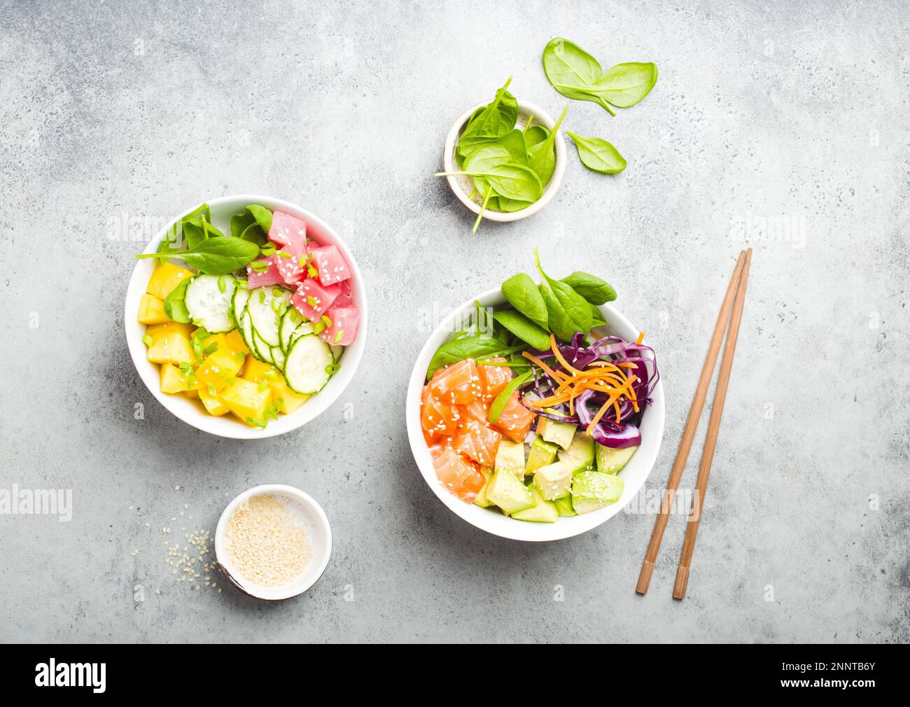 Two assorted poke bowls, raw tuna, salmon, vegetables, fruit. Top view ...