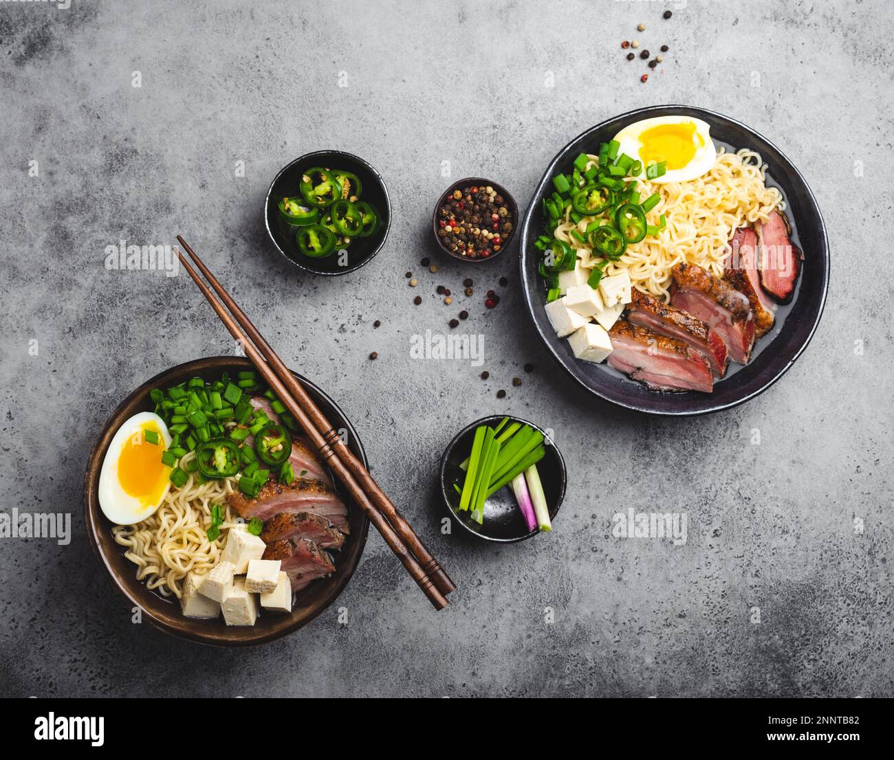 Two bowls of tasty Asian noodle soup ramen with meat broth, tofu, pork ...