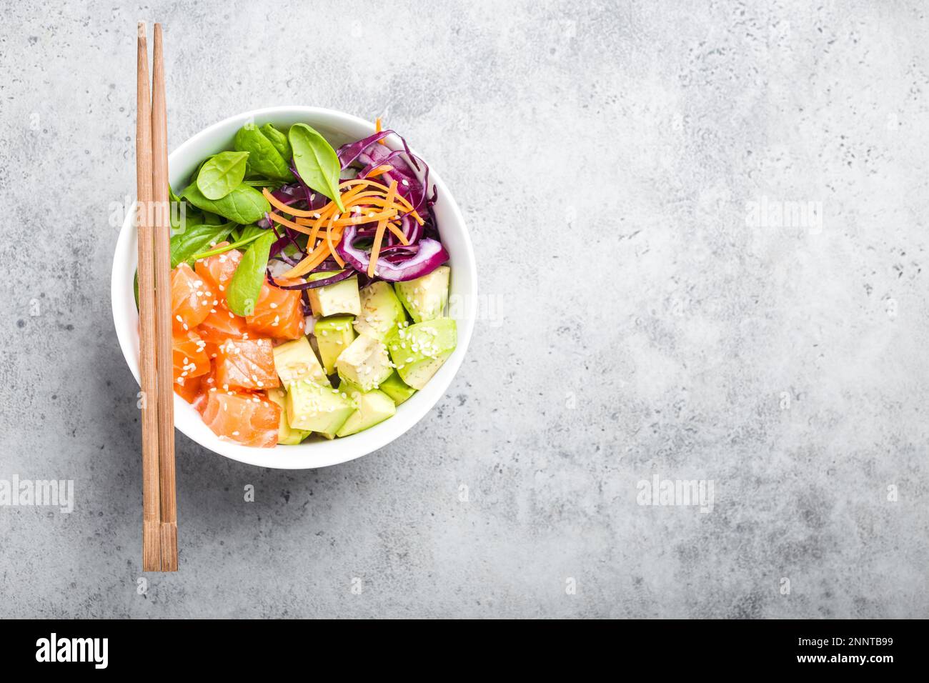 Top view of poke bowl with fresh raw salmon and vegetables, space for ...