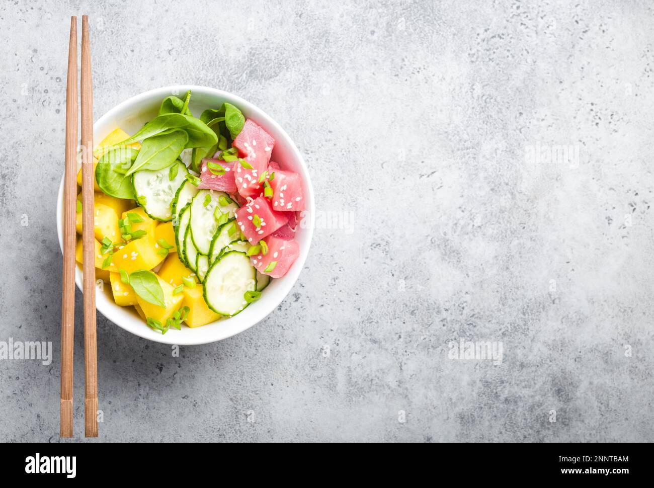 Top view of poke bowl with fresh raw tuna, fruit, vegetables, space for ...