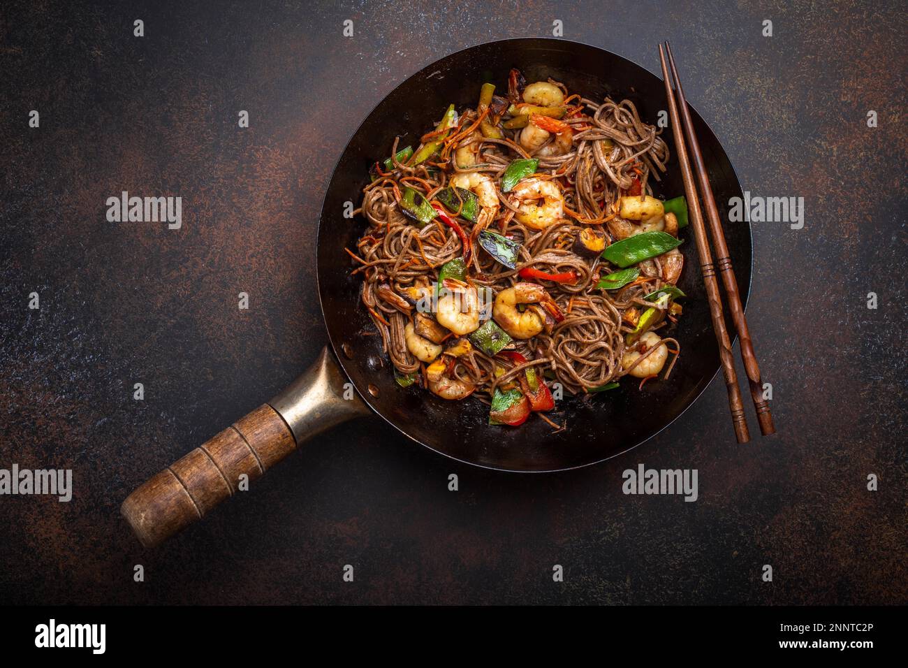 Chinese soba stir-fry noodles with shrimps, vegetables in old rustic ...