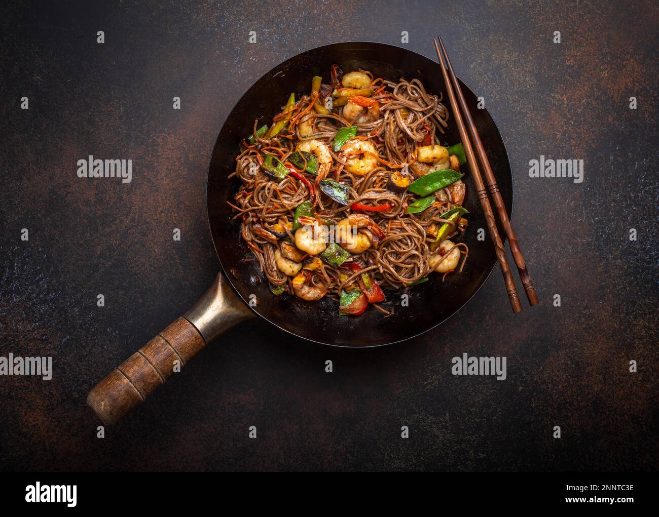 Chinese soba stir-fry noodles with shrimps, vegetables in old rustic ...