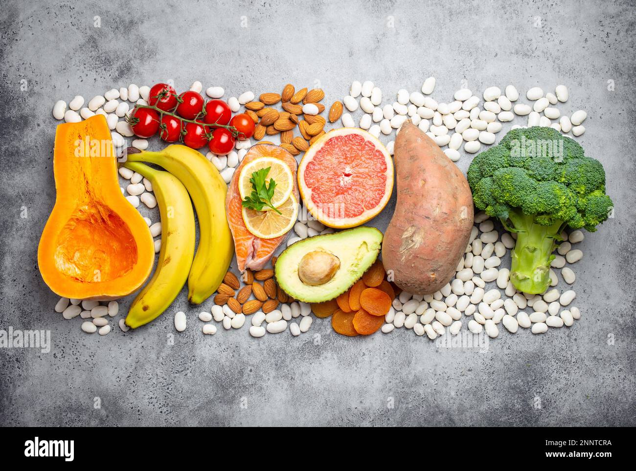 Vegetables, fruit and foods containing potassium over gray stone ...