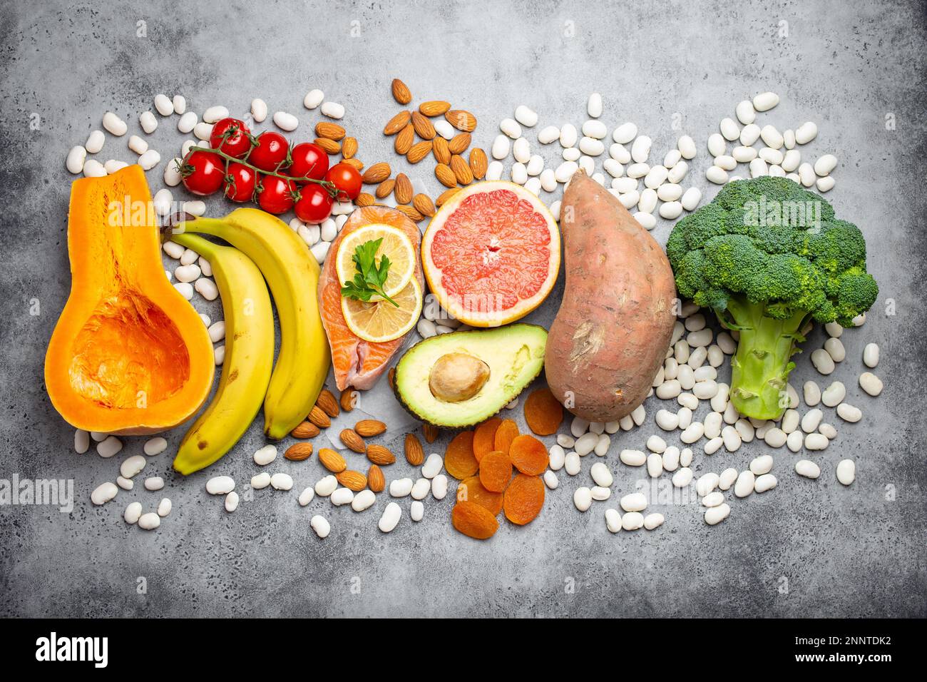 Vegetables, fruit and foods containing potassium over gray stone ...