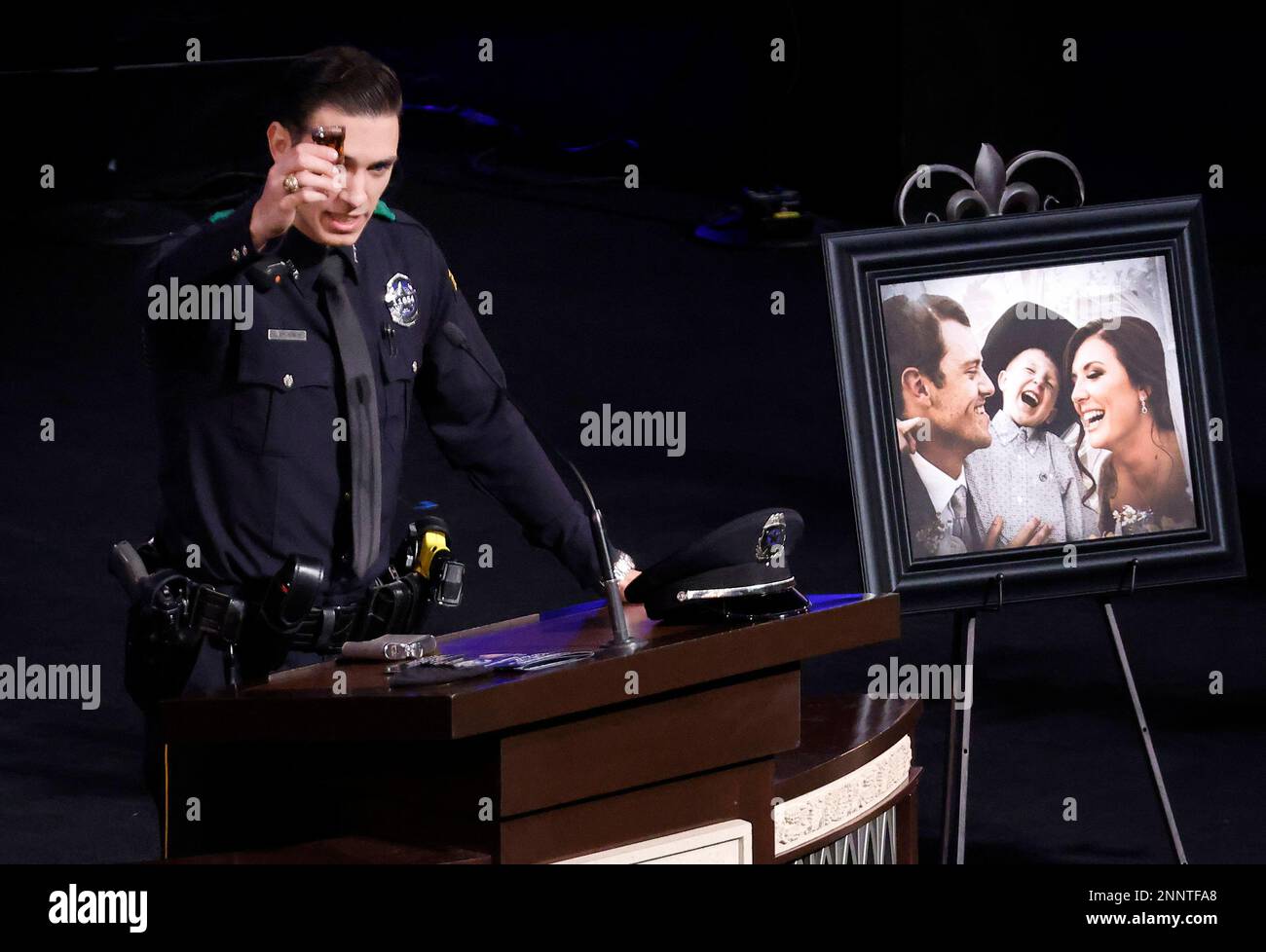 Dallas Police officer Colton Upchurch raises a shot glass of whiskey in ...