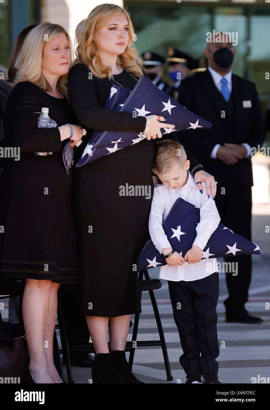 Nole Bergenske Penton, center, and her son Cashton grip folded U.S ...