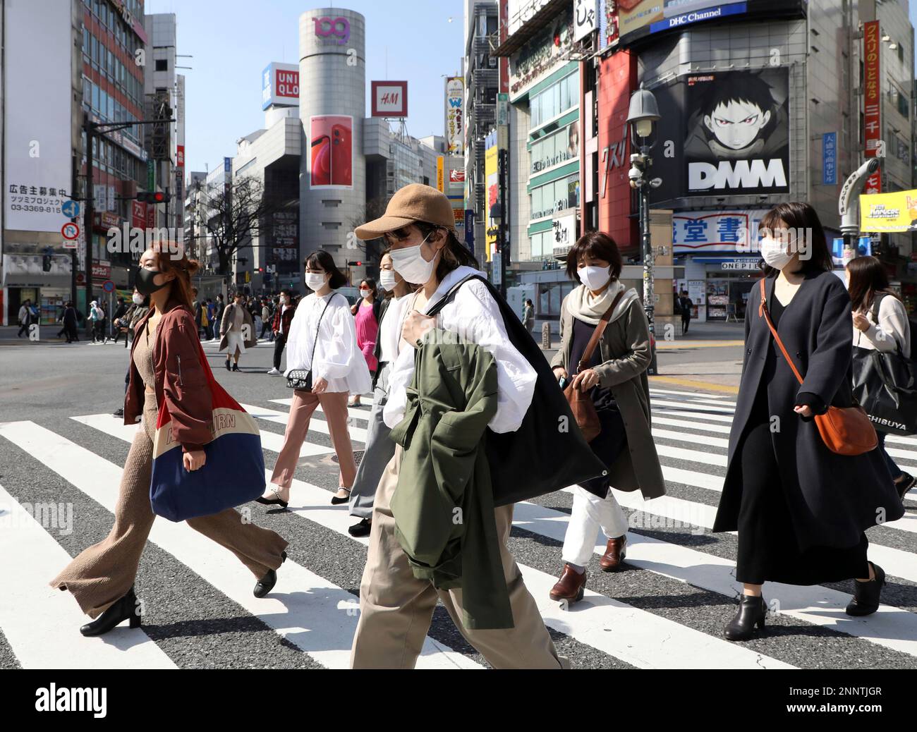 People wearing masks walk in a warm sunlight in Shibuya, Tokyo on Feb ...