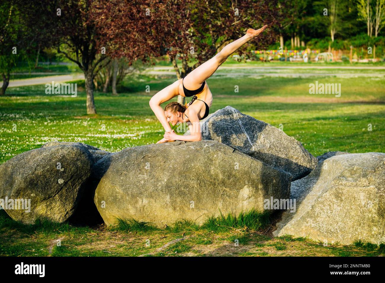 Female contortionist stretching on boulder, Battle Point Park ...