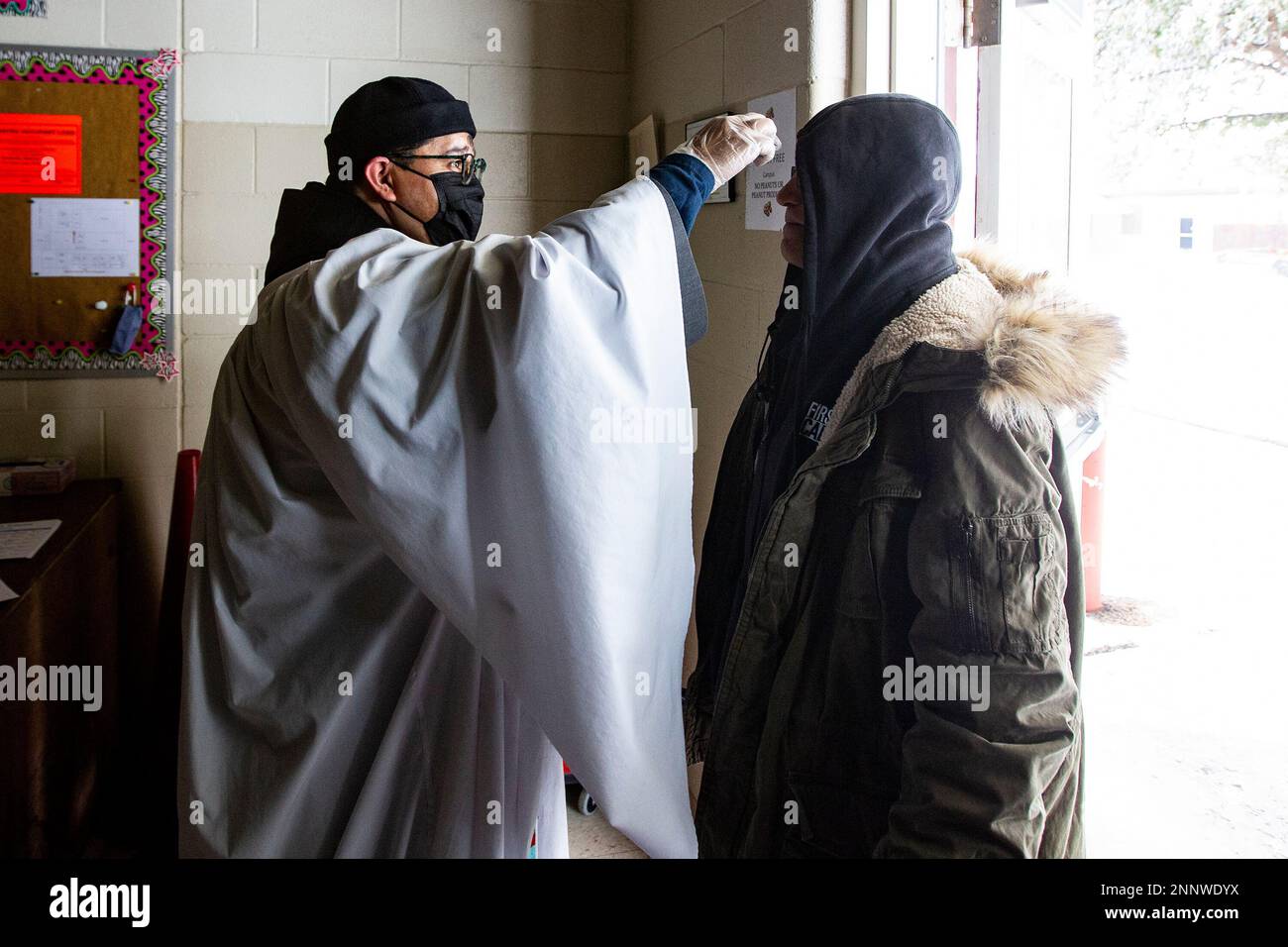 Rev. Ricky Lopez, left, applies ashes to the forehead of Hector Gaspar ...
