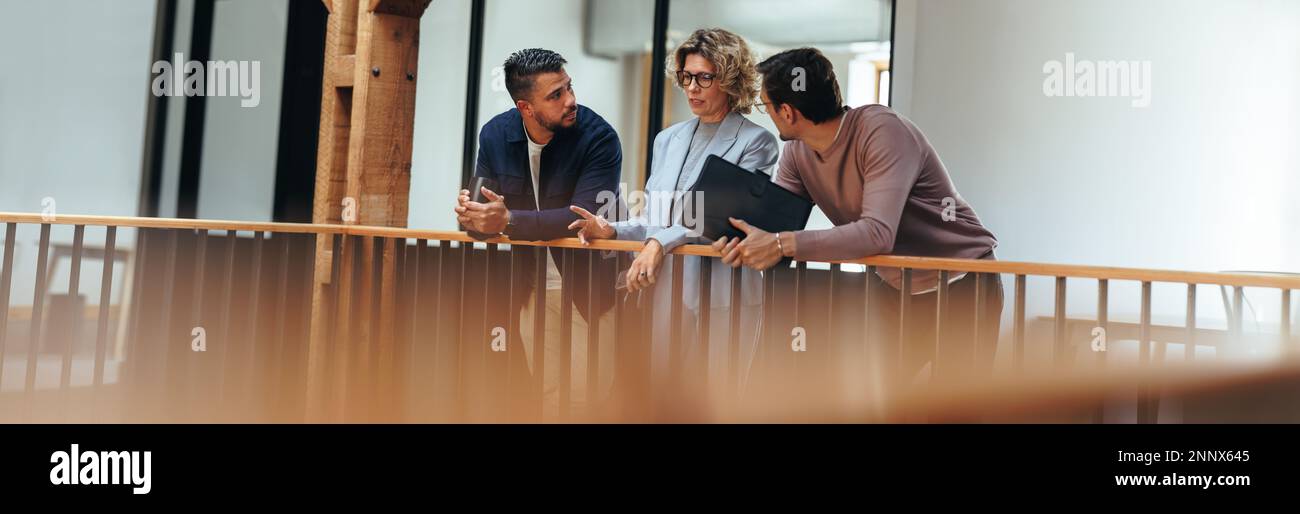 Discussion in an office. Three business people talking on an interior ...