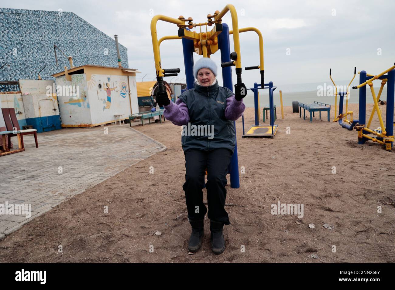 An elderly woman trains in the outdoors gym at the embankment of the ...