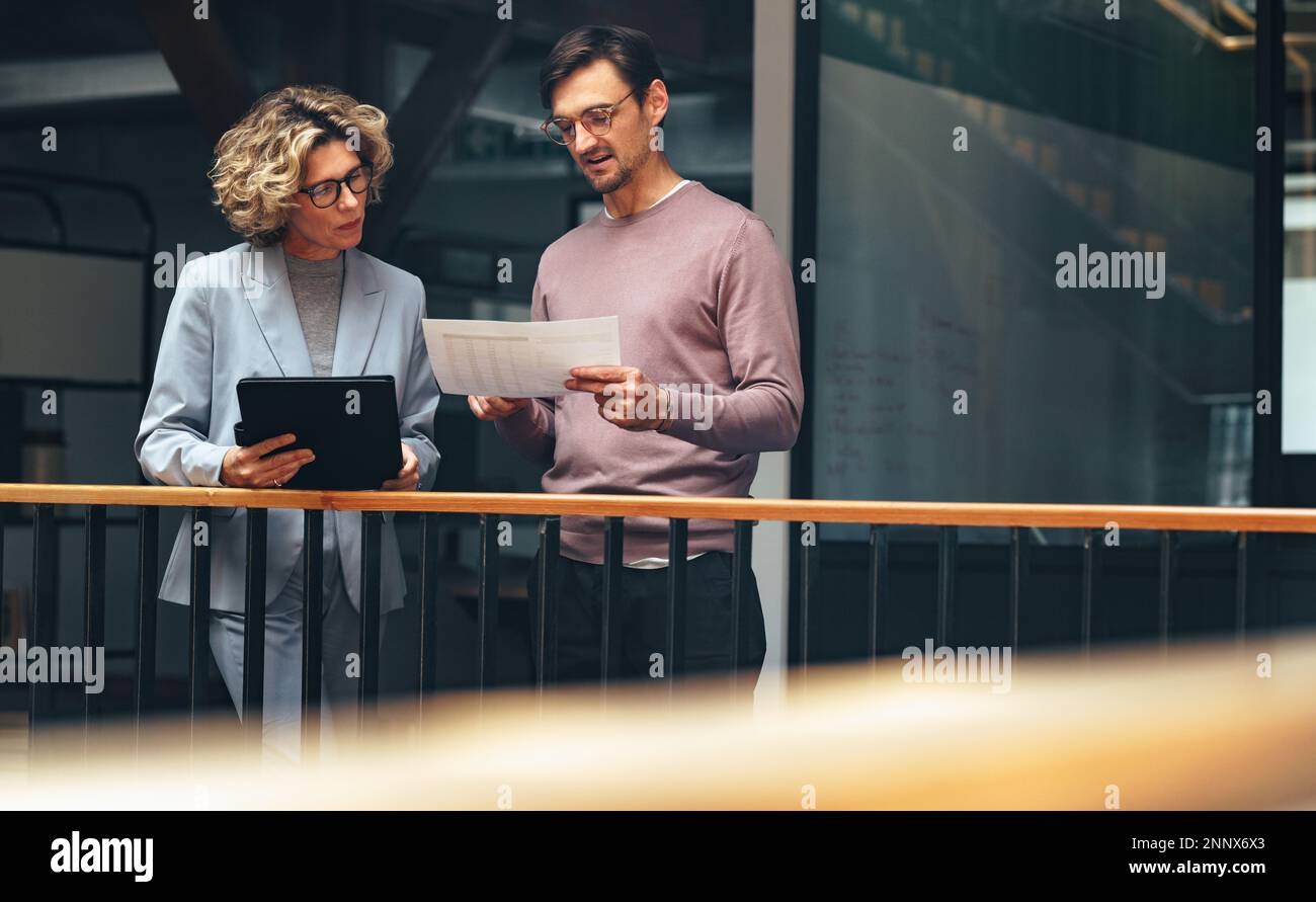 business people reading a document together. Two professionals analyse ...