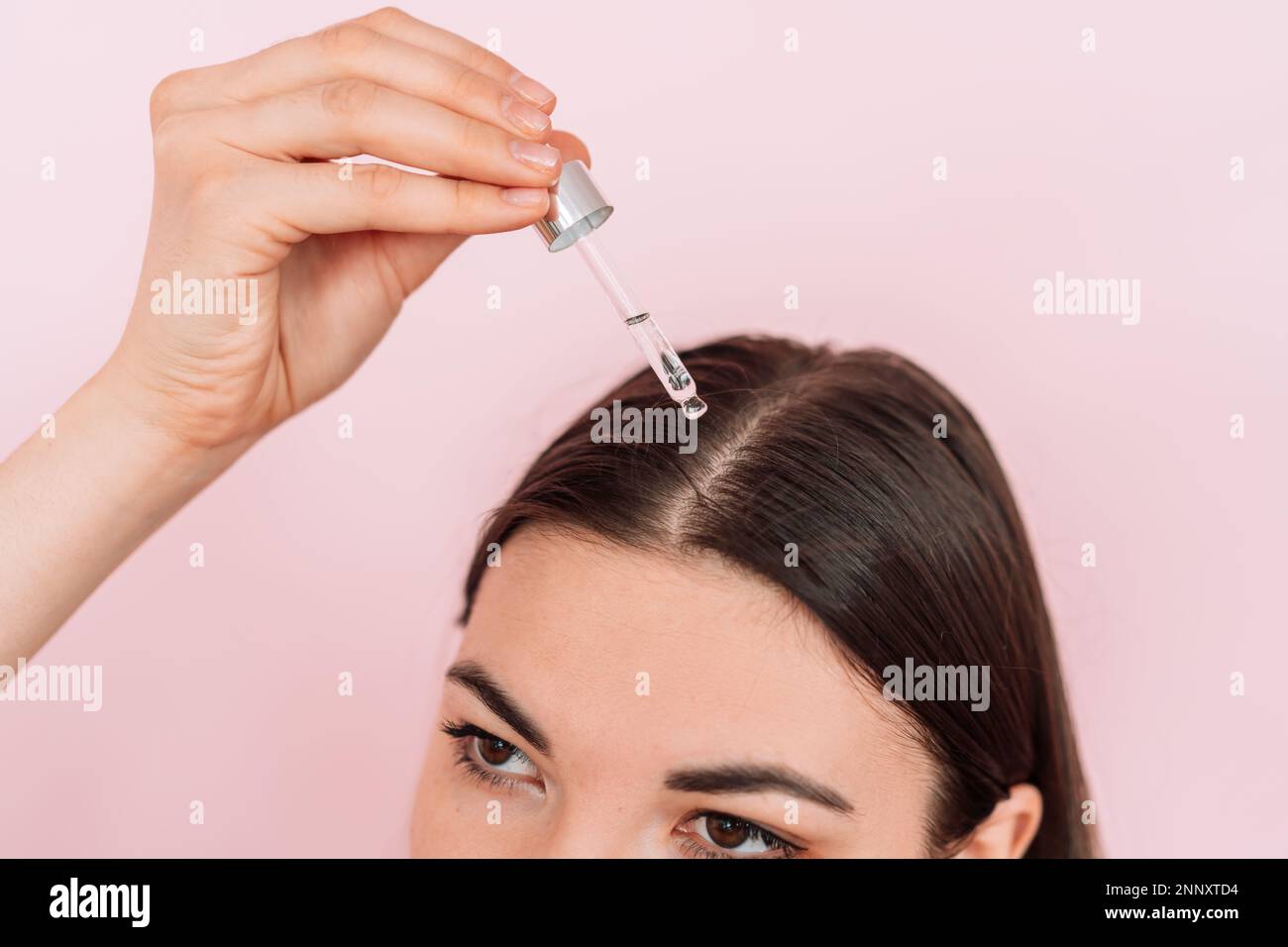 Lady drops a pipette into her head parting Stock Photo - Alamy