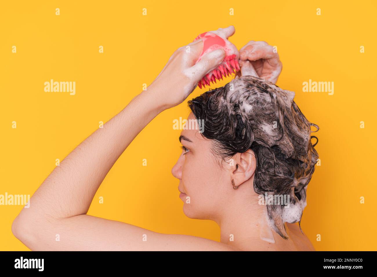 Lady with foam on her head takes care of her scalp with silicone ...