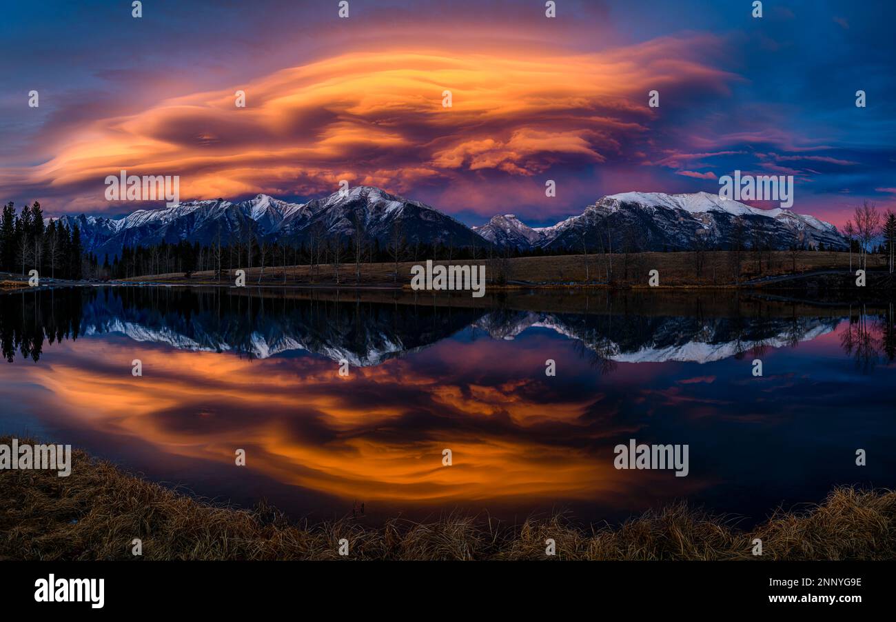 Chinook clouds over Grotto Mountain reflected in Quarry Lake at sunset ...