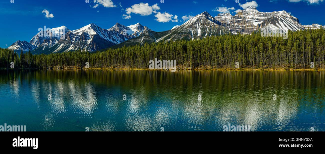 Snow-covered mountain peaks and Herbert Lake, Mt. Temple, Mt. Fairview ...
