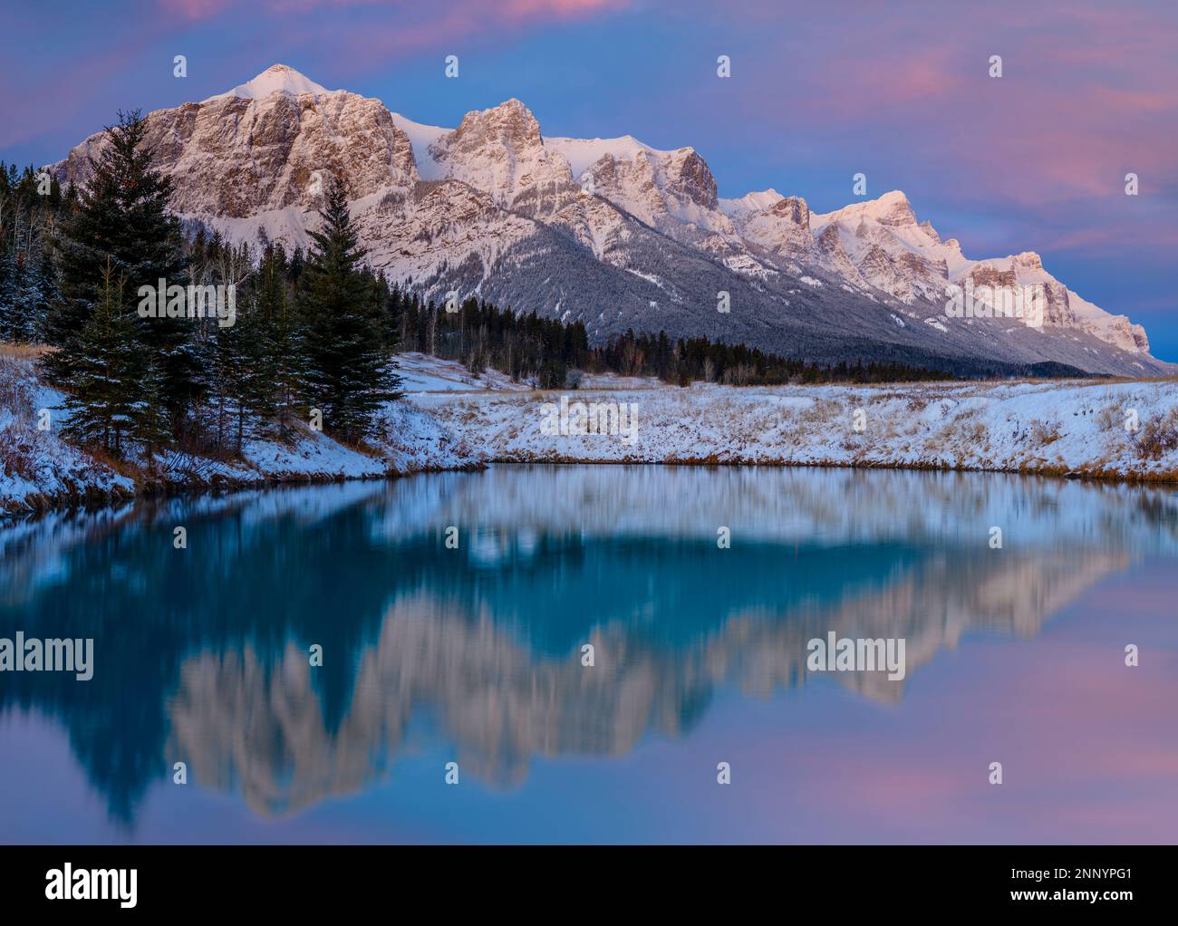 Mount Rundle reflecting in lake at sunrise in winter, Canmore, Alberta ...