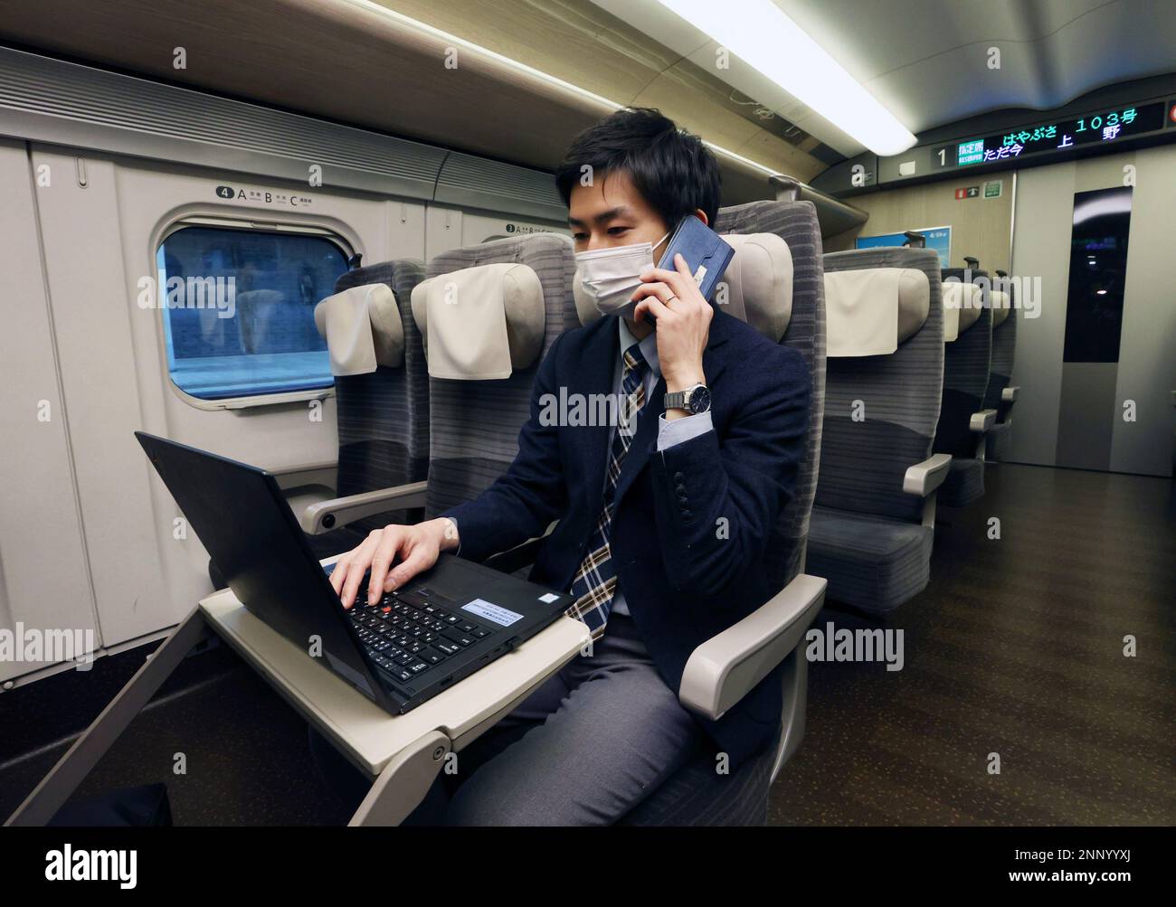 JR-East employee uses a mobile in a train of Shinkansen Bullet Train ...