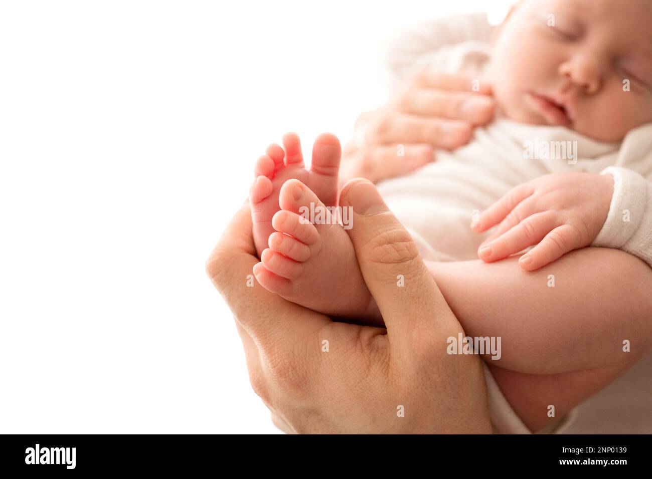 Top view of a newborn girl lying in a white overalls in the arms of her parents Stock Photo - Alamy
