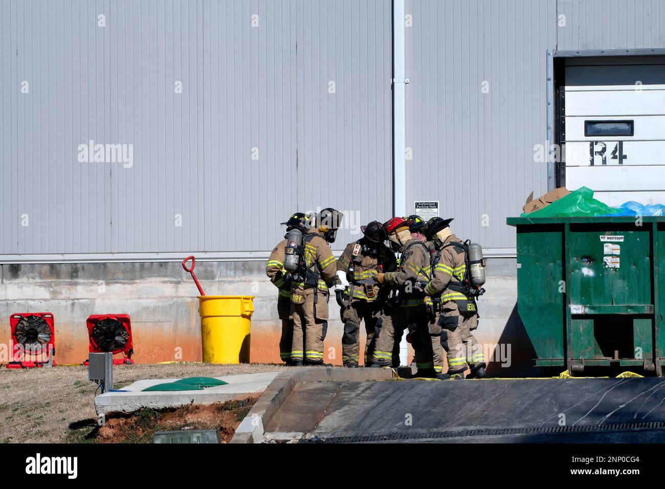 Two Hall County Firefighters gather outside before entering a building ...