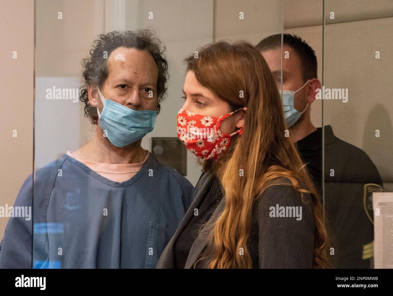 Motorist Paul Rivas, 64, speaks behind a protective glass alongside ...