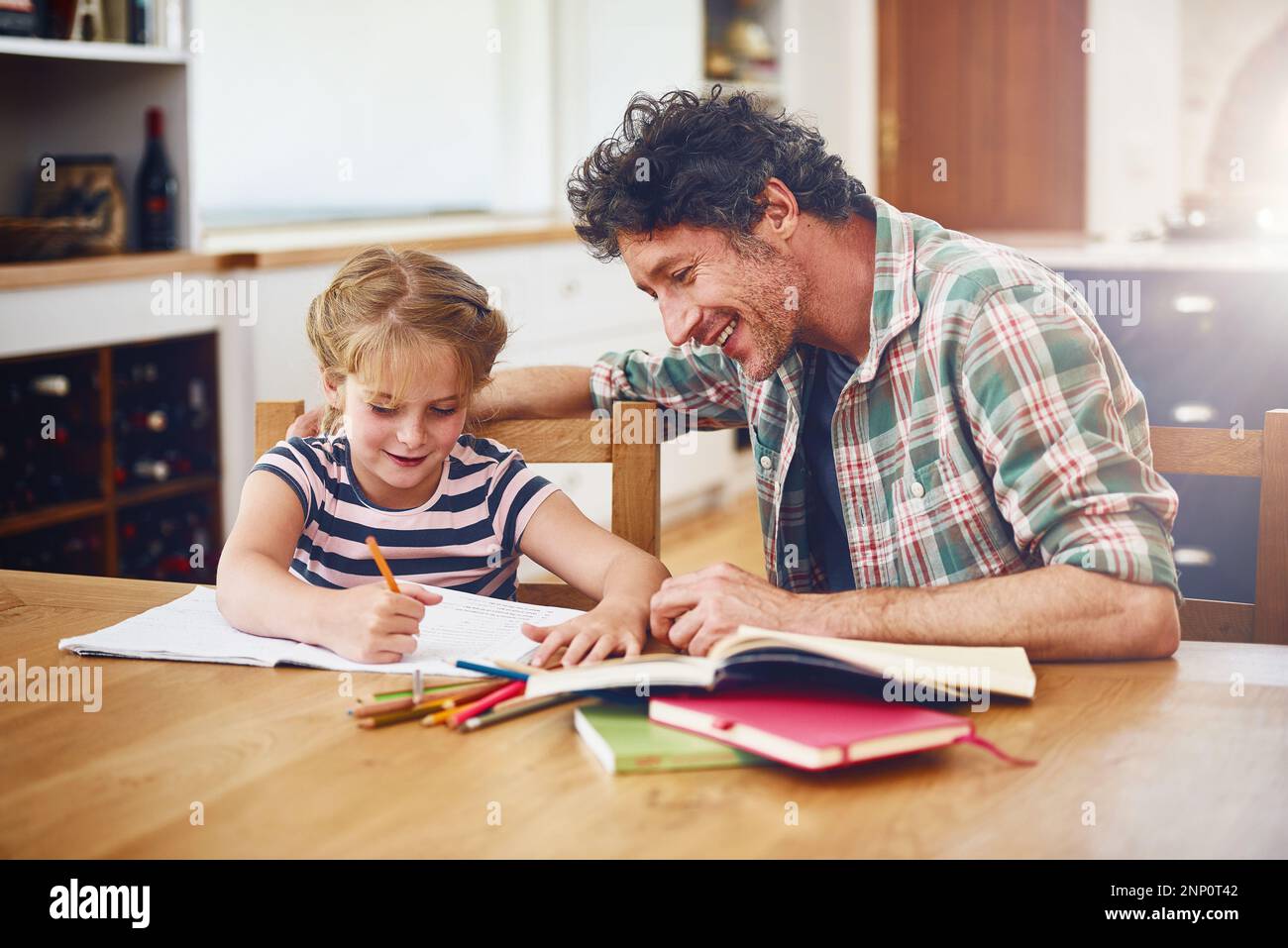 Monitoring homework time. a father helping his daughter with her ...