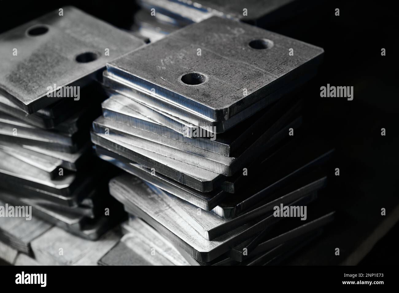 Stacks of metal plates with holes in plant storehouse Stock Photo - Alamy