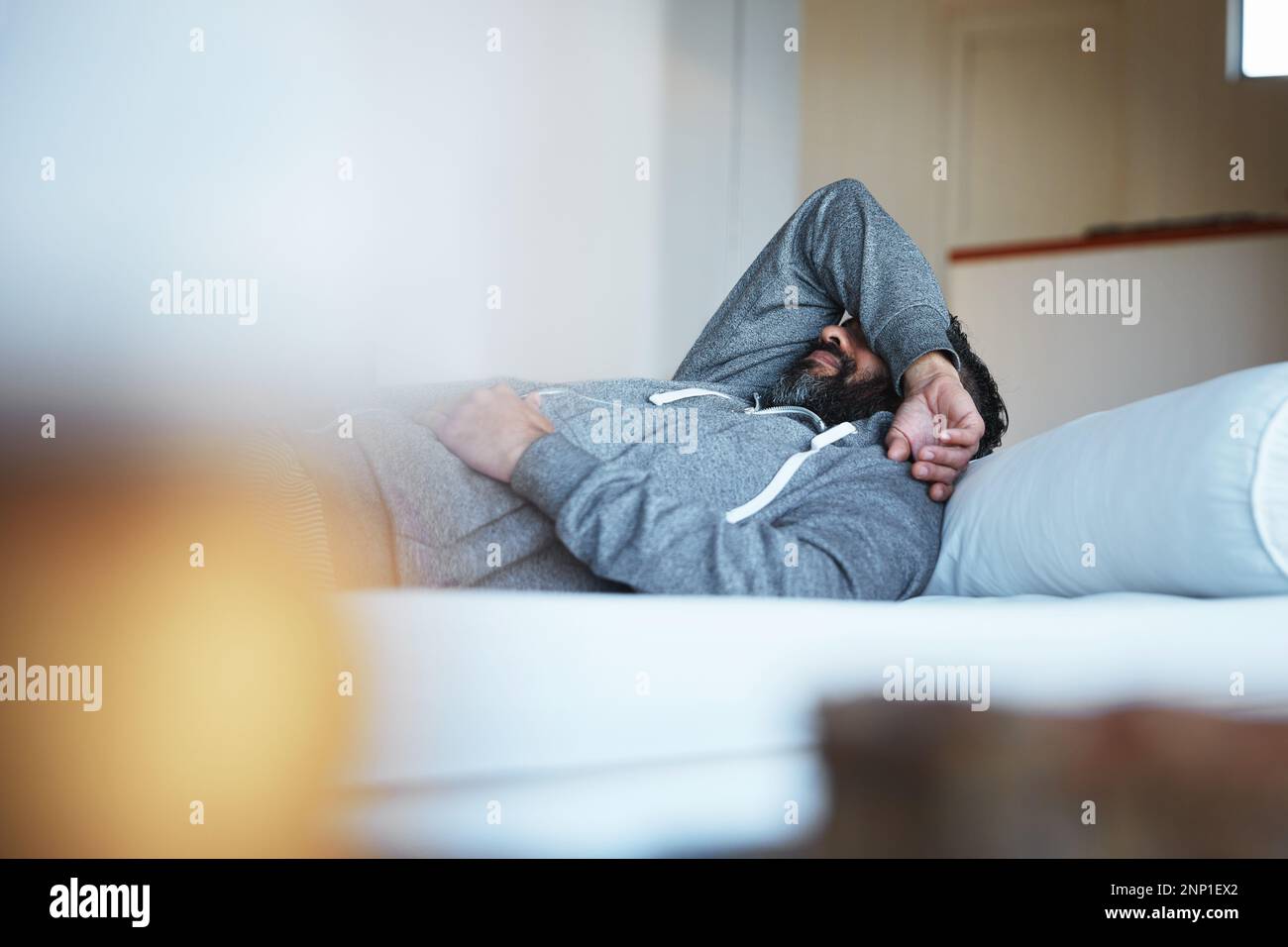 Just tired of everything. a mature man lying on his bed feeling ...