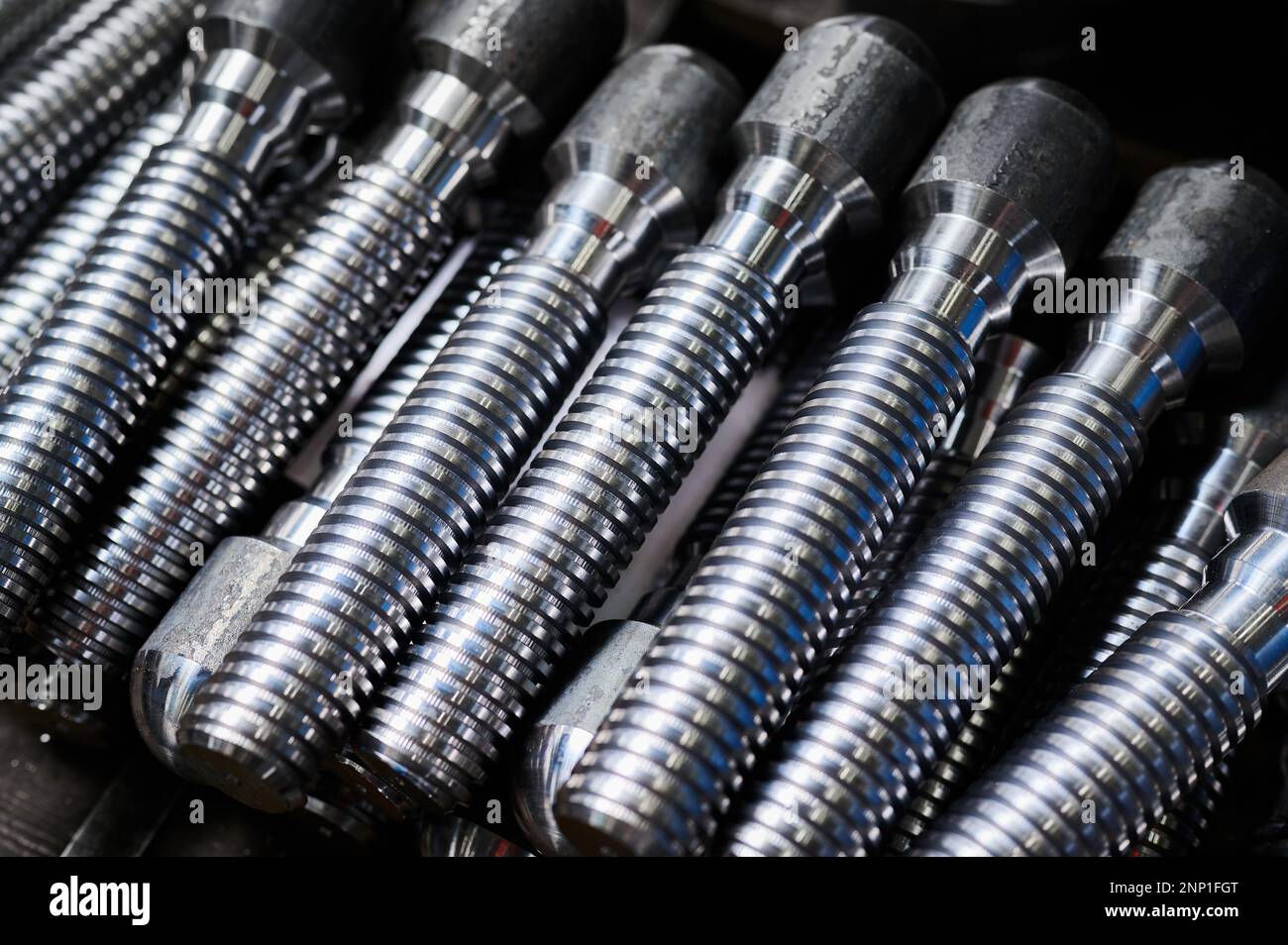 Large shiny bolts stack in plant warehouse macro view Stock Photo - Alamy
