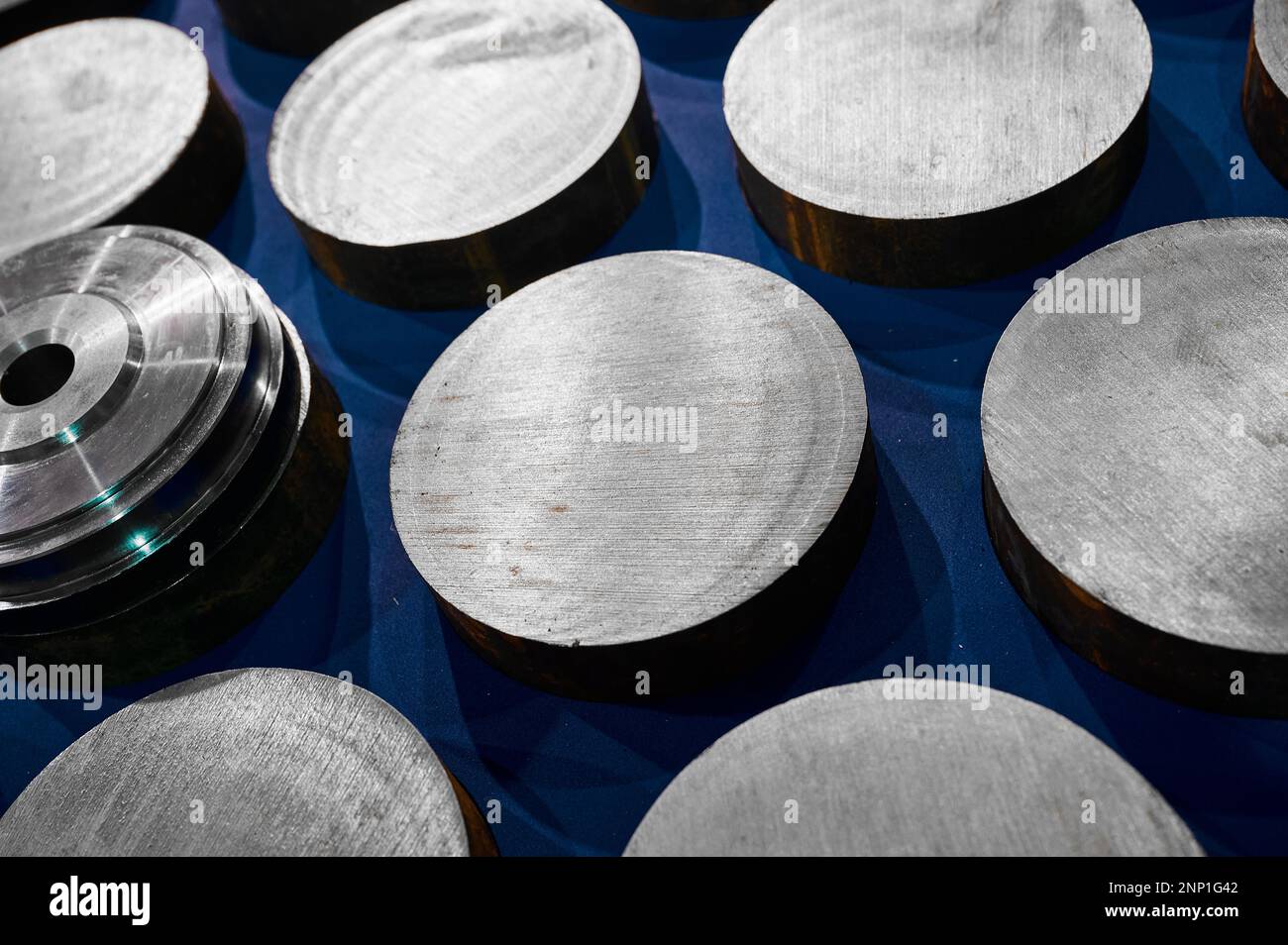 Cut round metal details on blue background closeup Stock Photo - Alamy