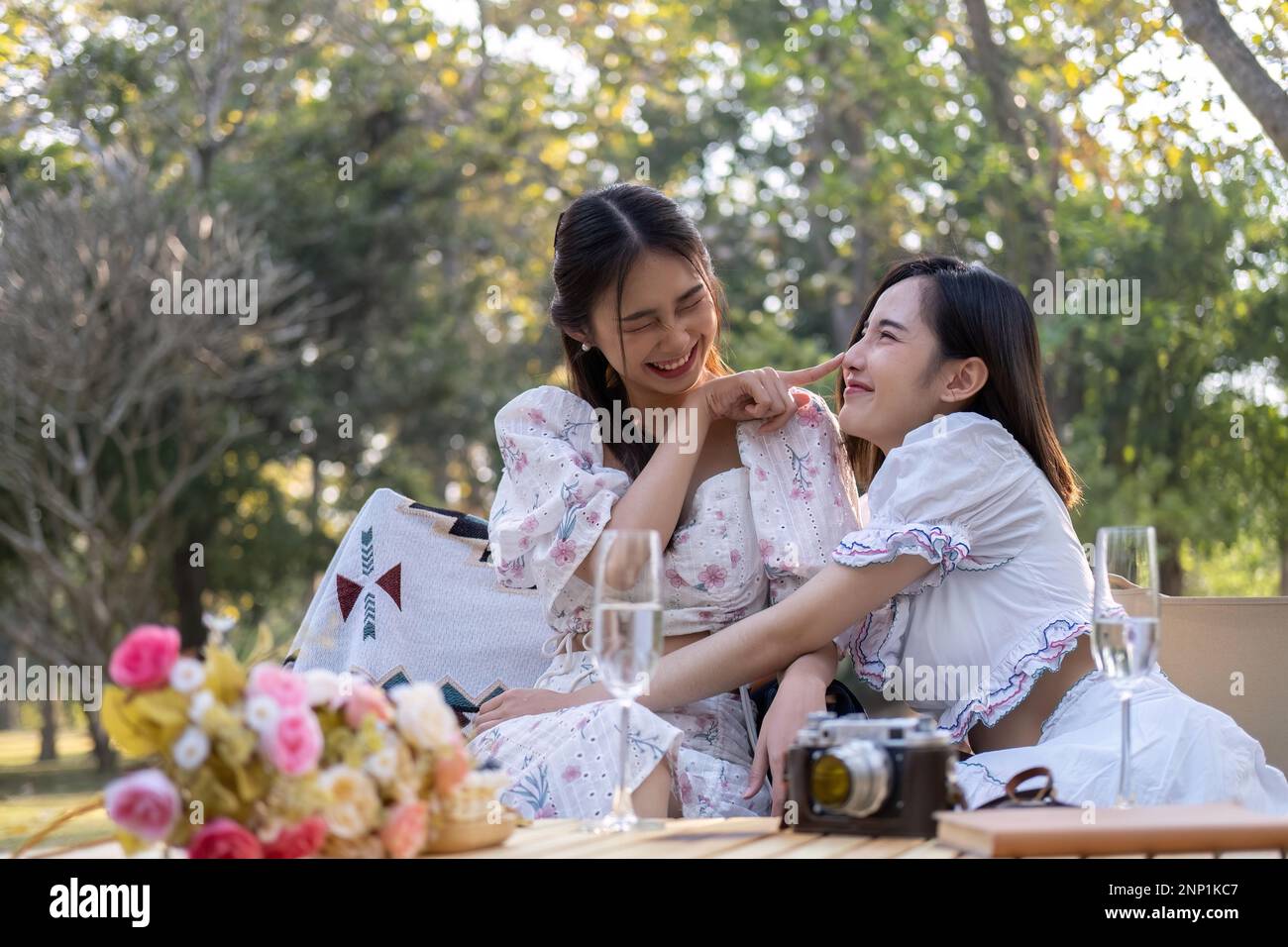 Two beautiful Asian female besties cuddle, sharing a special moment ...