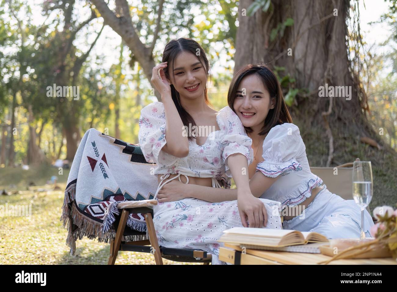 Two beautiful Asian female besties cuddle, sharing a special moment ...