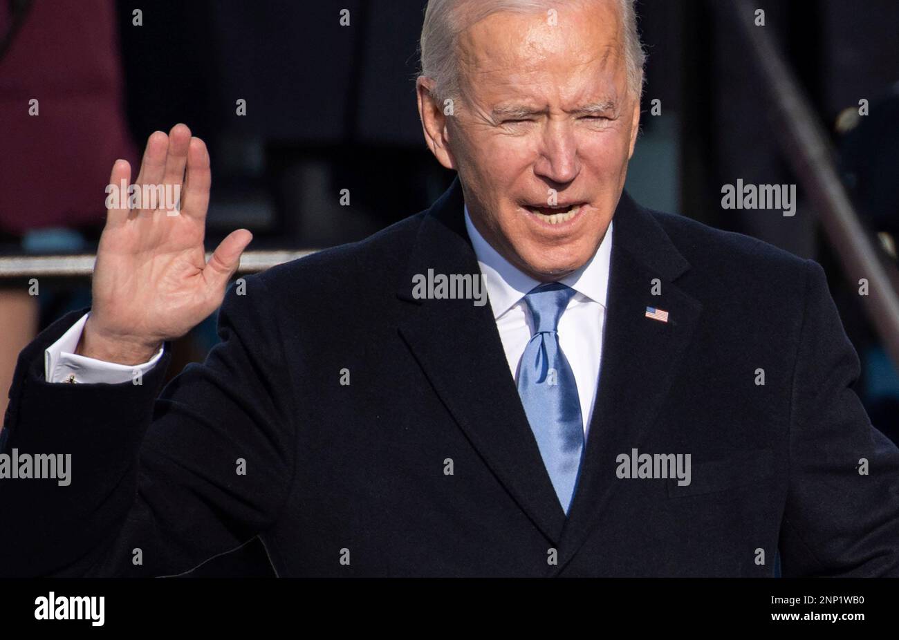 Joe Biden holds up his right hand as he is sworn in as the 46th ...