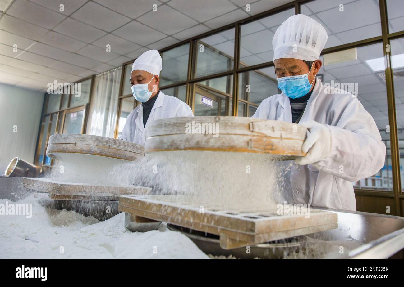 Workers make traditional rice cakes in a factory in Hai'an city in east ...