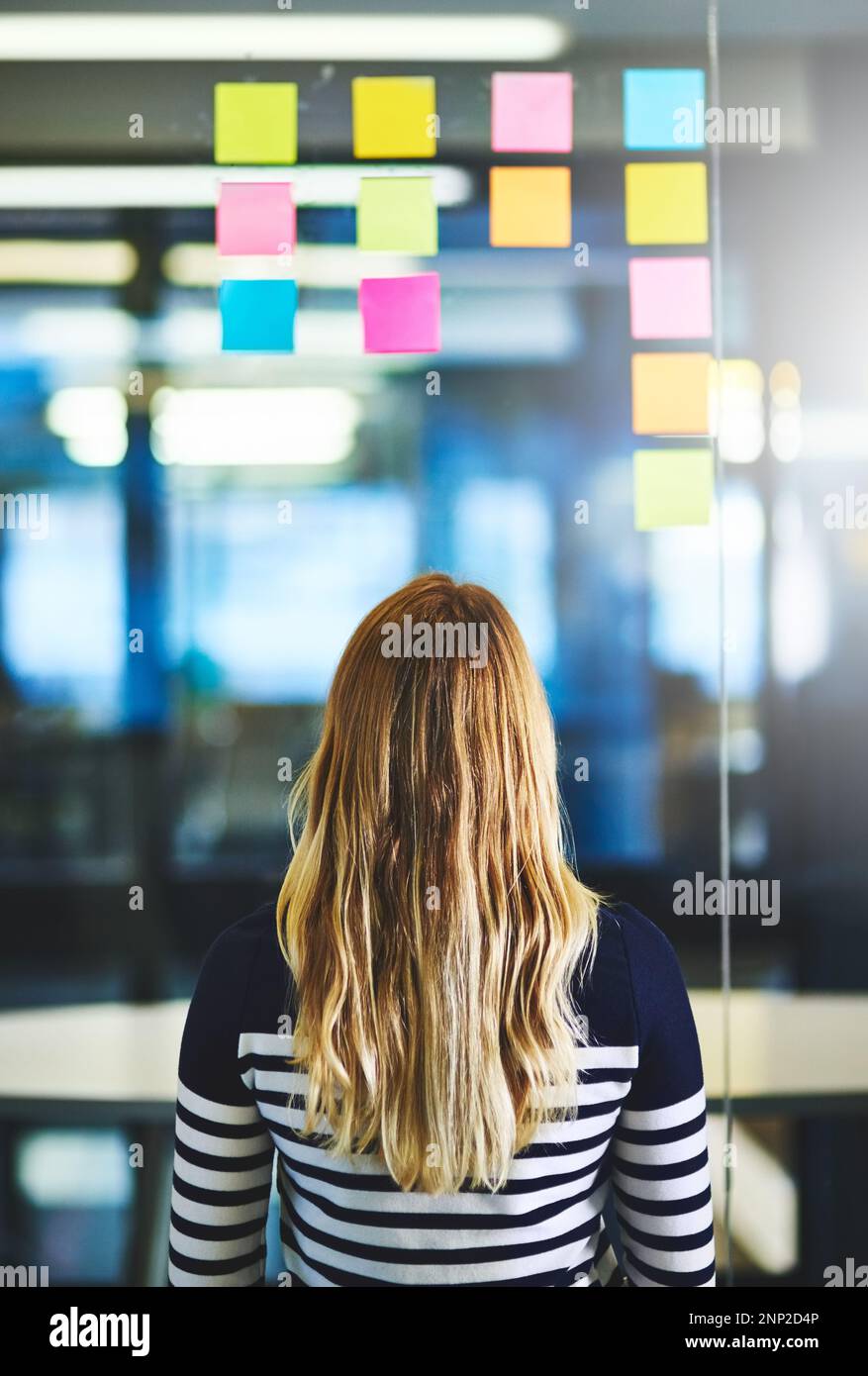 Driving creativity with critical thinking. Rearview shot of a woman ...