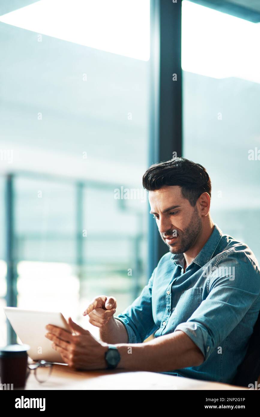 Getting work done in digital format. a young businessman using a ...