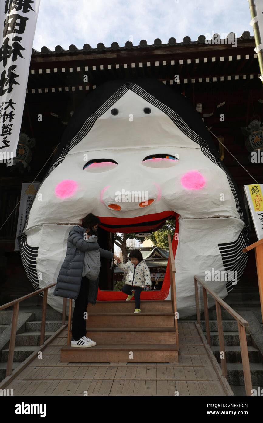 A large mask of an otafuku (a round-faced woman with a flat nose) has ...