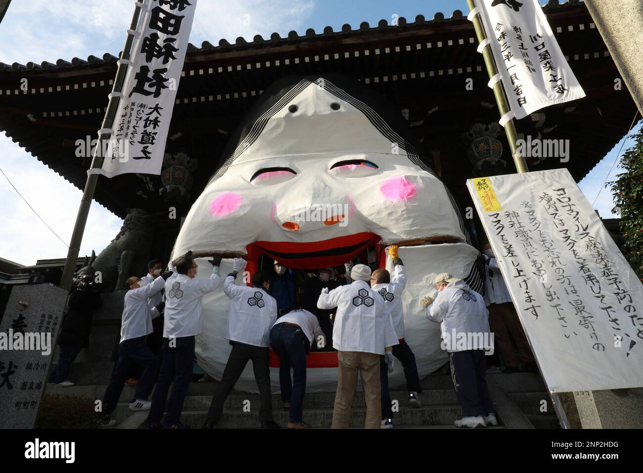 A large mask of an otafuku (a round-faced woman with a flat nose) has ...