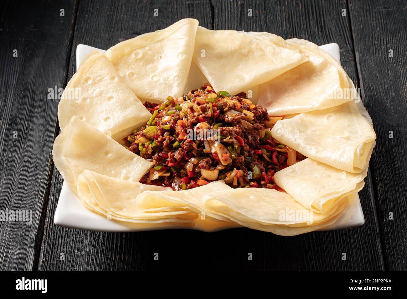 Portion of fried asian meat with tortillas Stock Photo - Alamy